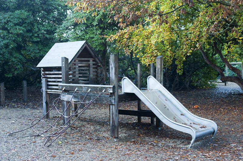 Free image of Kids playground with slide under green trees